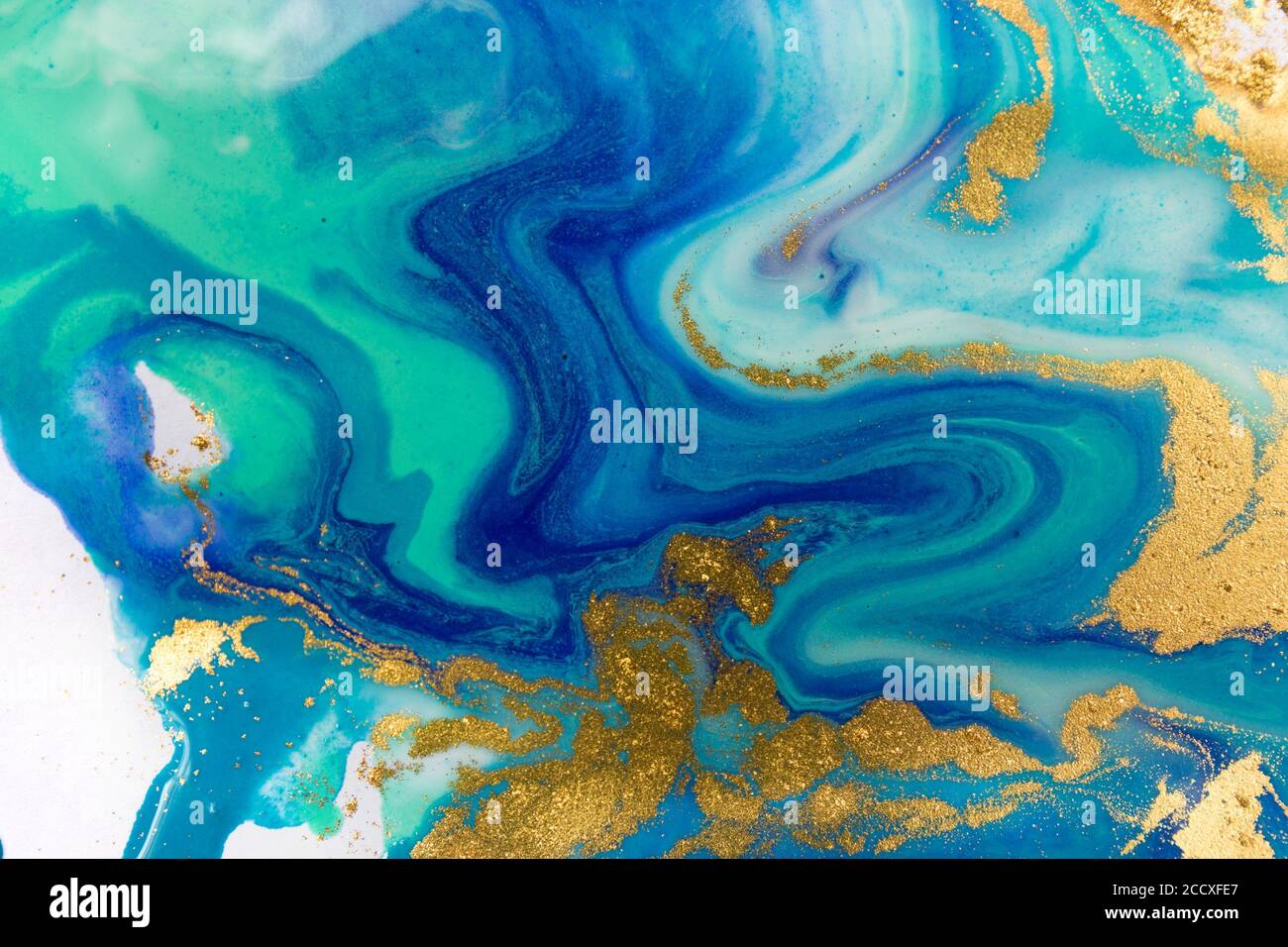 Gold and blue mixed inks splattered on white paper background Stock ...