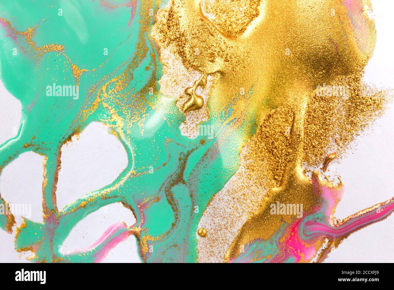 Gold, green and pink inks splattered on white paper background. Golden ...