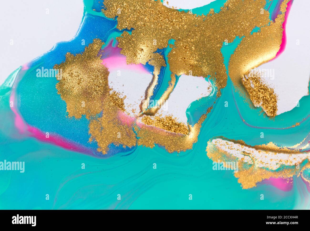 Gold and blue mixed inks splattered on white paper background Stock ...