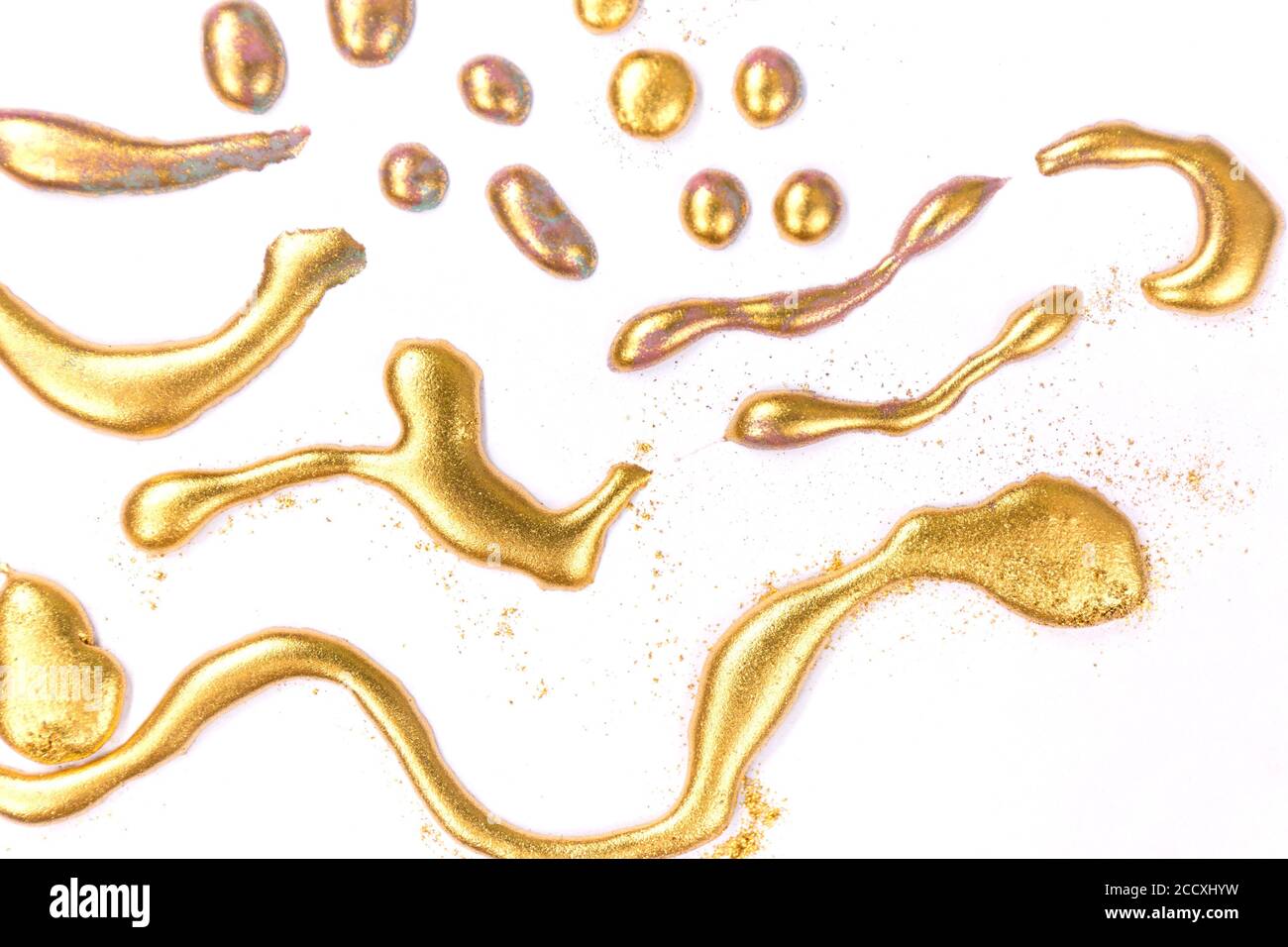 Golden ink drops on white paper background Stock Photo - Alamy