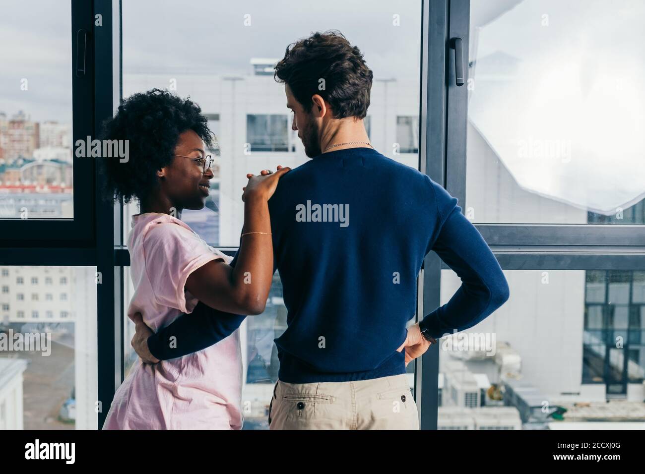 Backside view of young mixed race lovers staying in hotel, Hispanic man ...