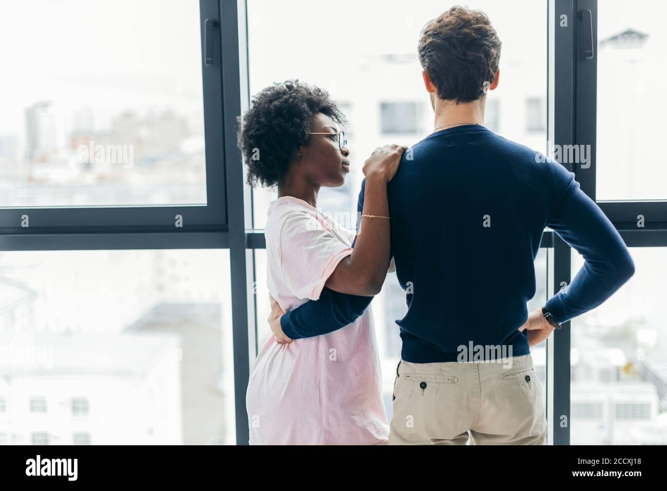 Backside view of young mixed race lovers staying in hotel, Hispanic man ...