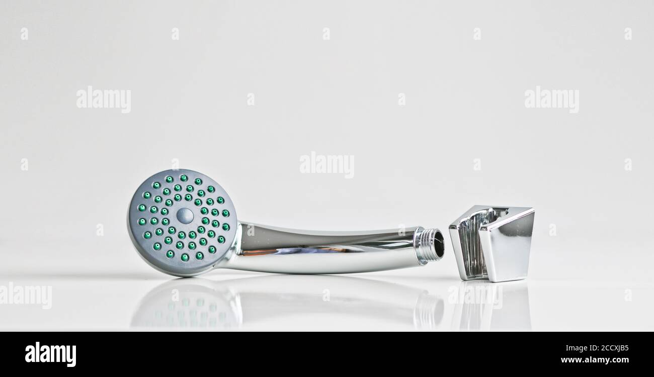 New shiny shower head and wall mount for it. On a light background ...