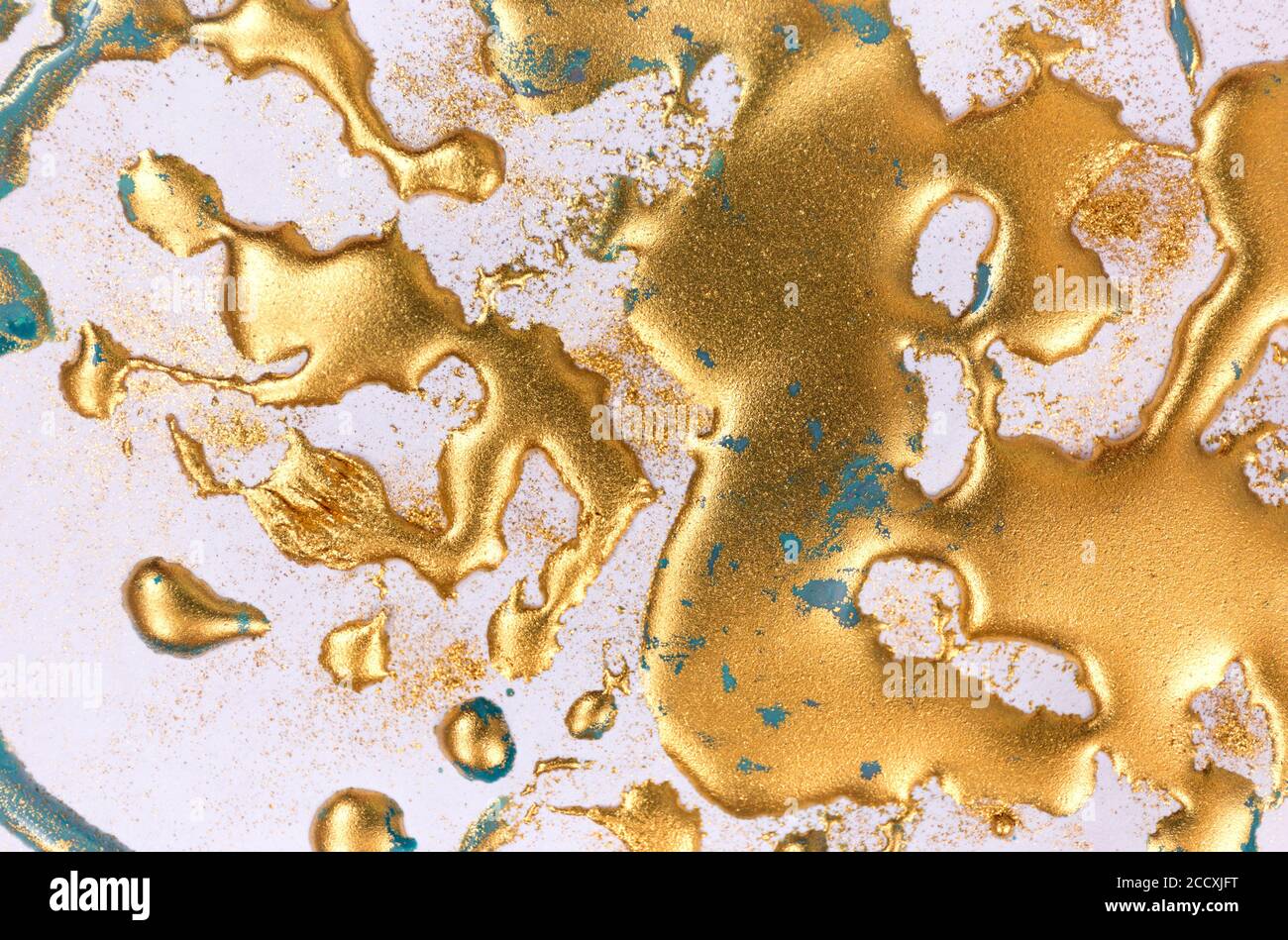 Golden ink drops on white paper background Stock Photo - Alamy
