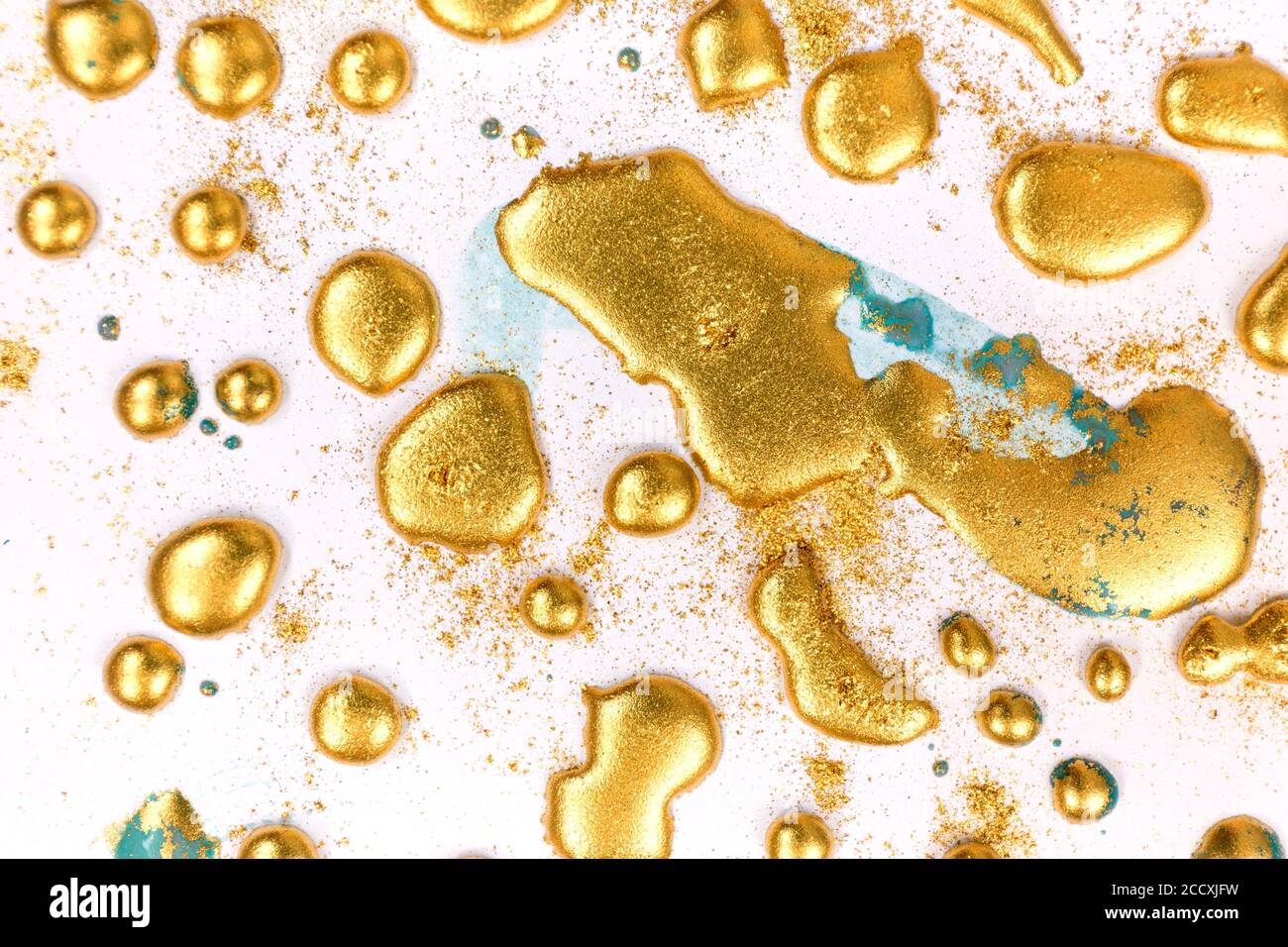 Golden ink drops on white paper background Stock Photo - Alamy