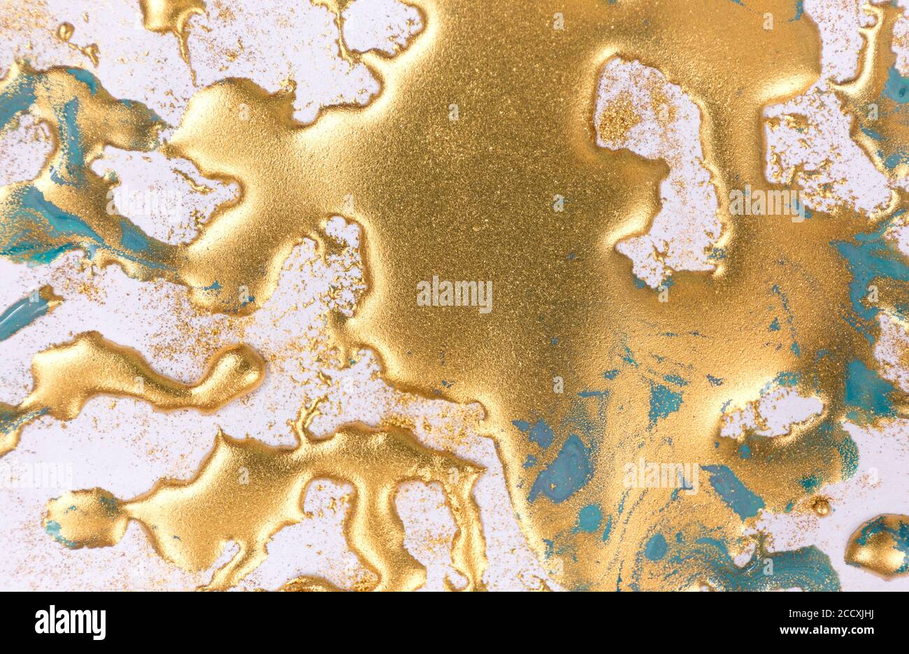 Golden ink drops on white paper background Stock Photo - Alamy