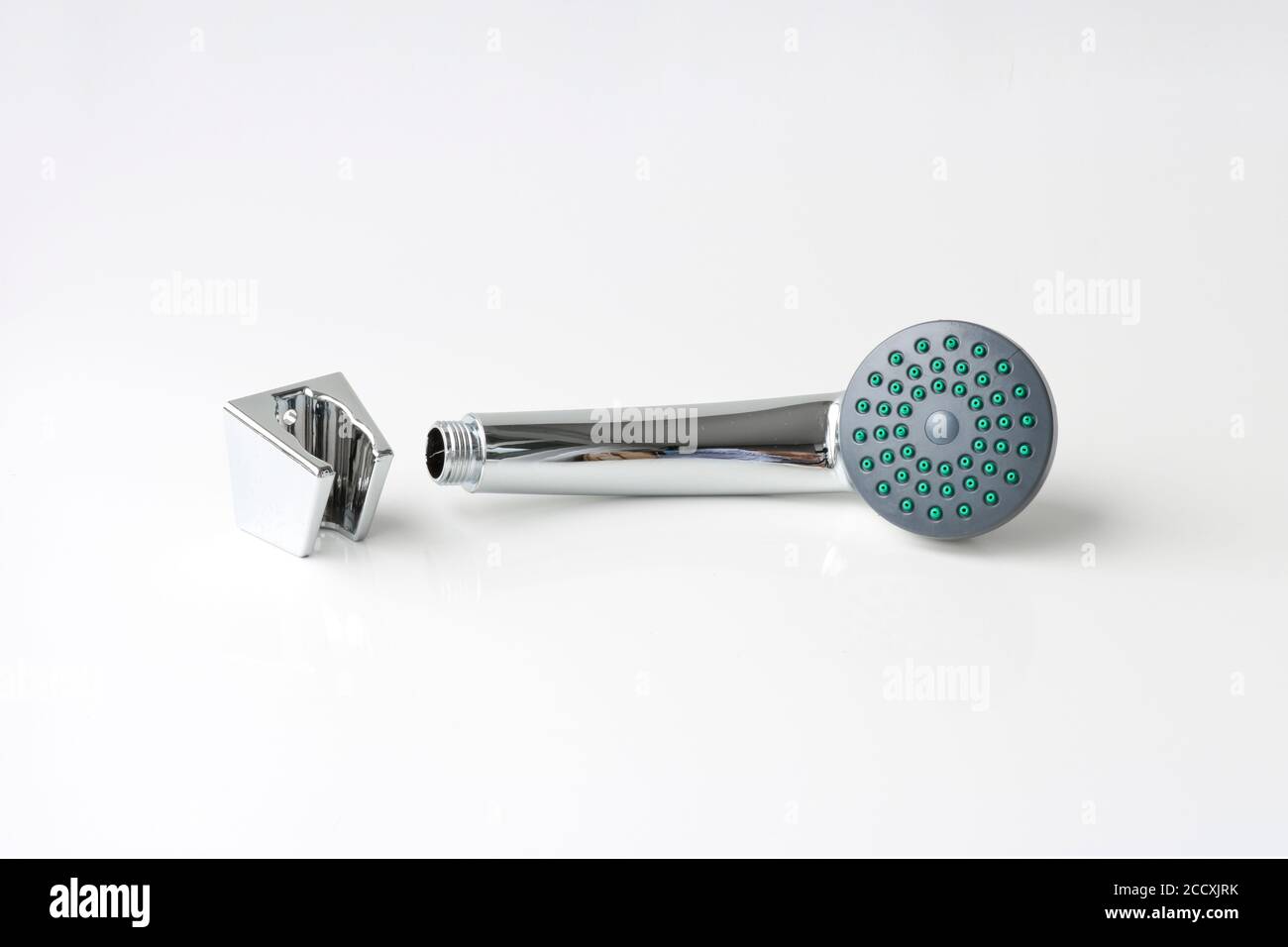 New shiny shower head and wall mount for it. On a light background ...