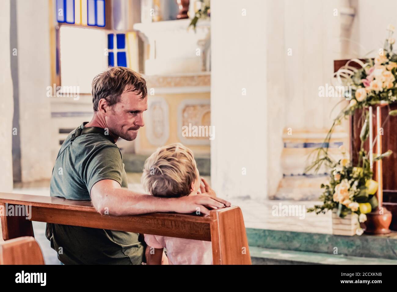 Christian dad tells his son Bible stories about Jesus sitting in kirk ...