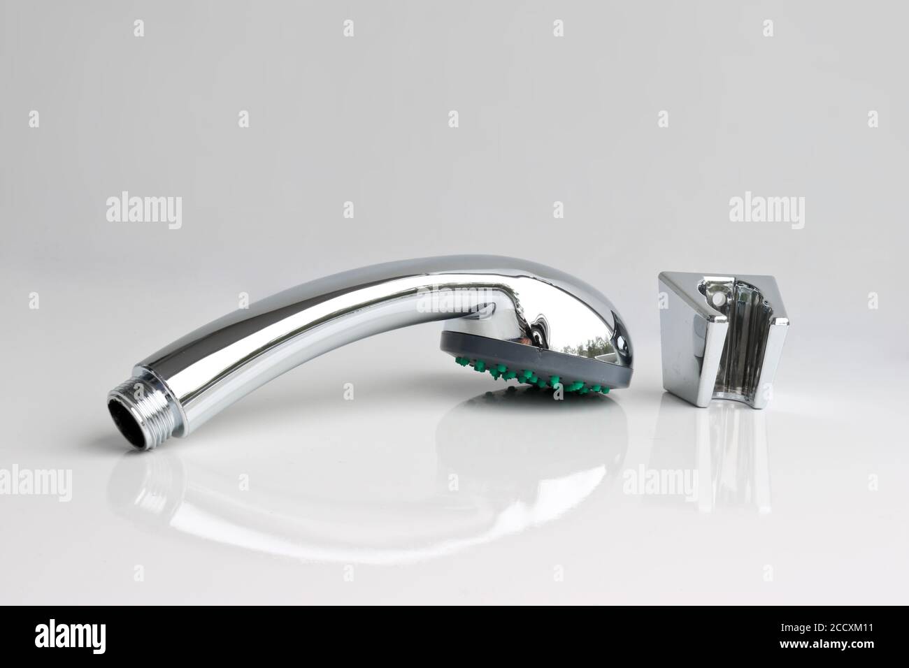 New shiny shower head and wall mount for it. On a light background ...