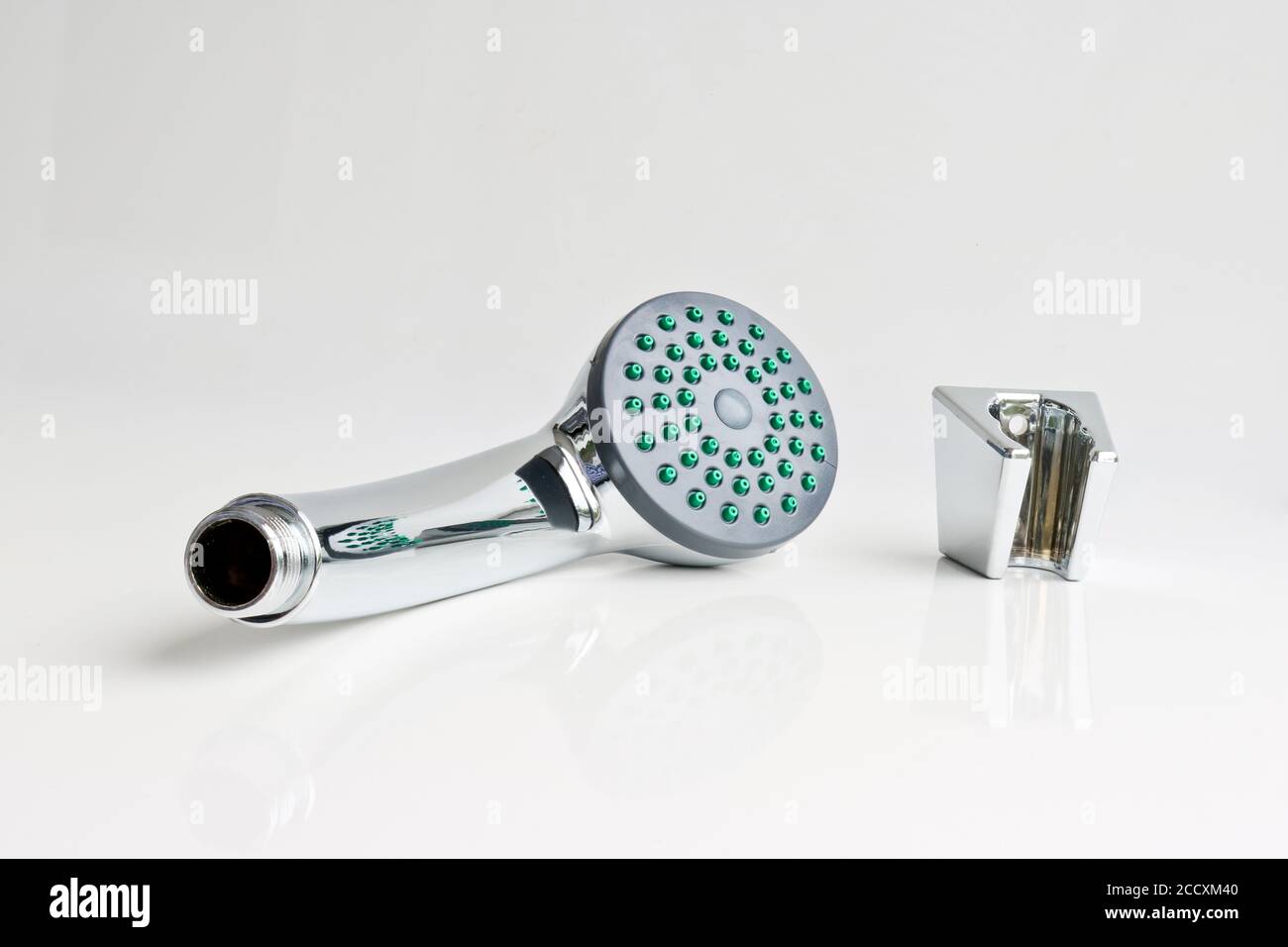 New shiny shower head and wall mount for it. On a light background ...