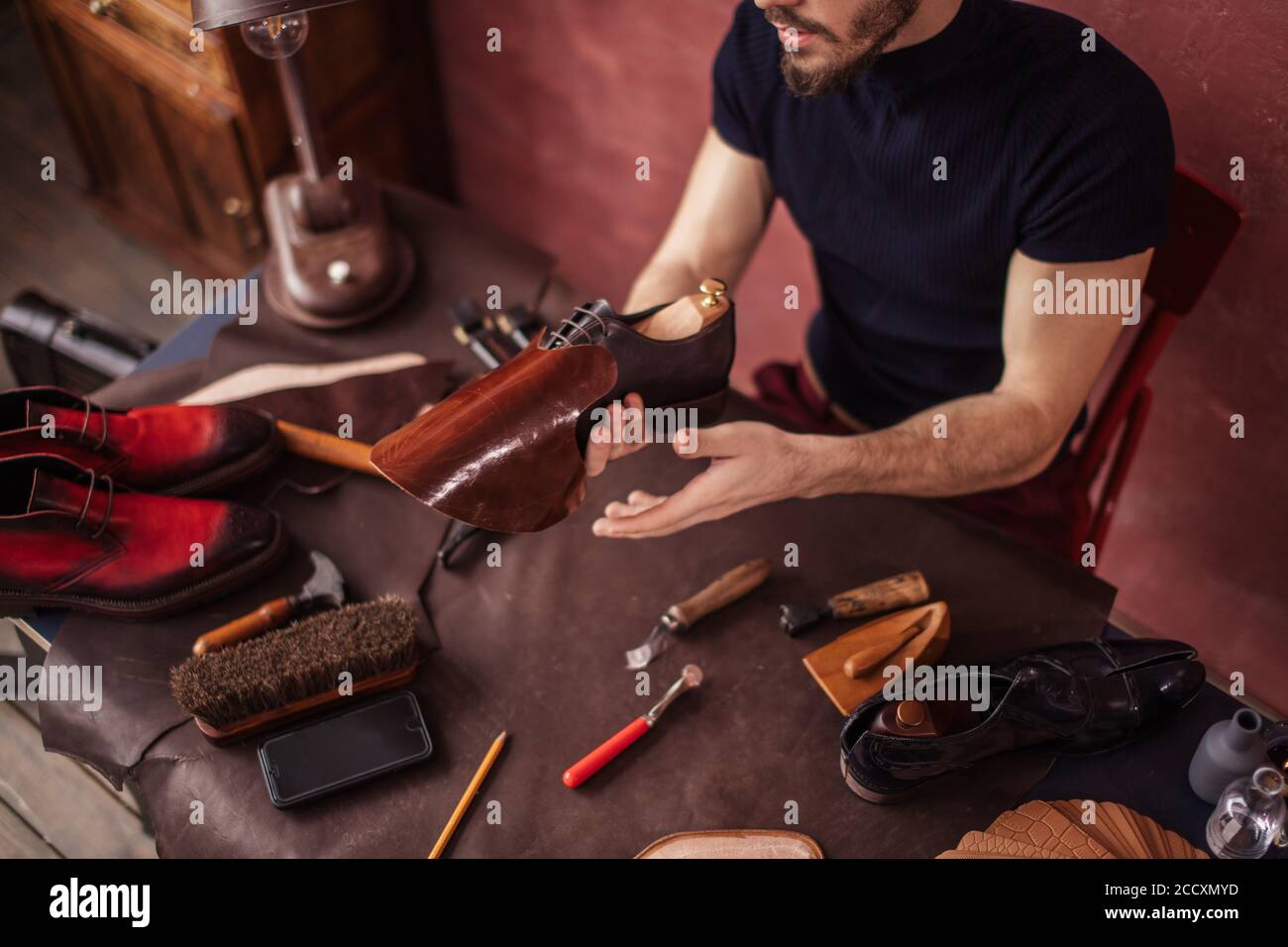 shoemaker putting on shoe into the leather. close up cropped photo ...