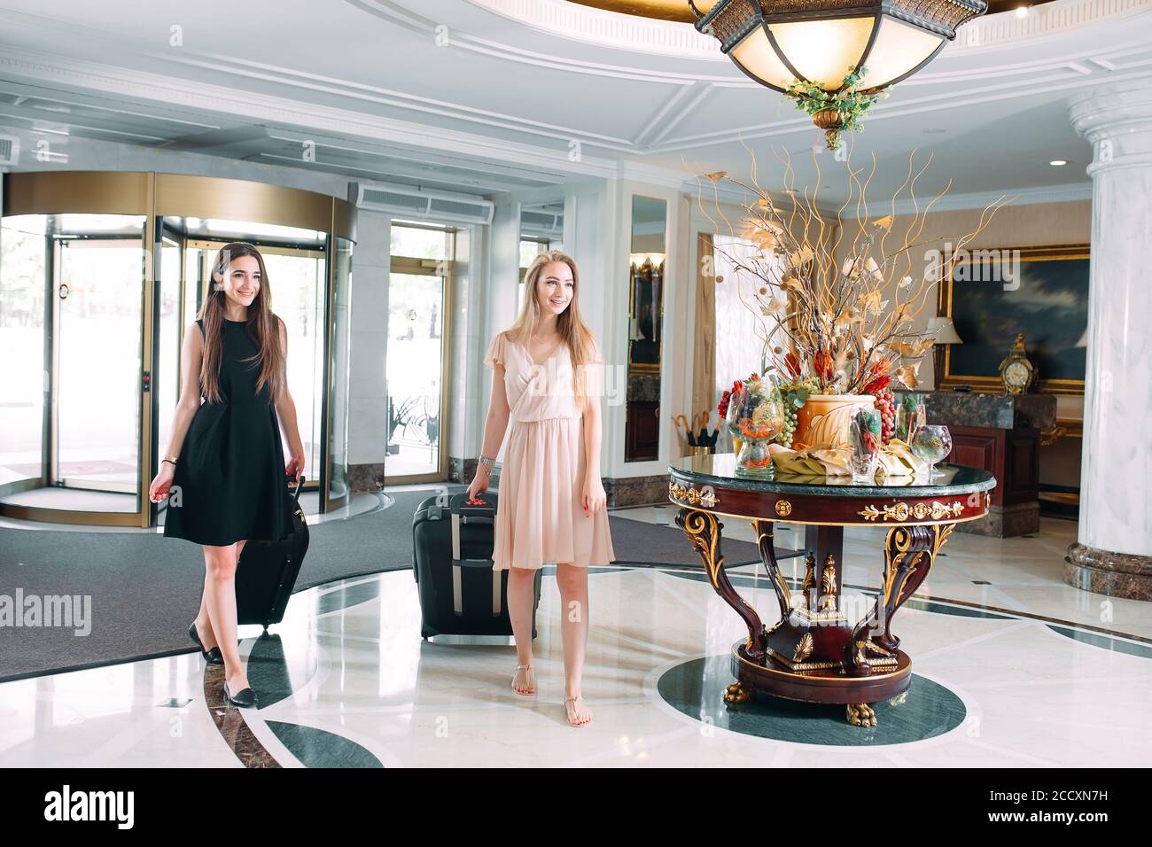 Young girls near reception desk in hotel. Young girls comes to the ...