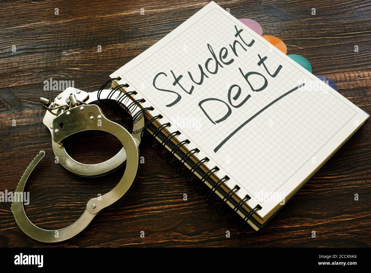 Student debt handwritten sign in notebook and handcuffs Stock Photo - Alamy