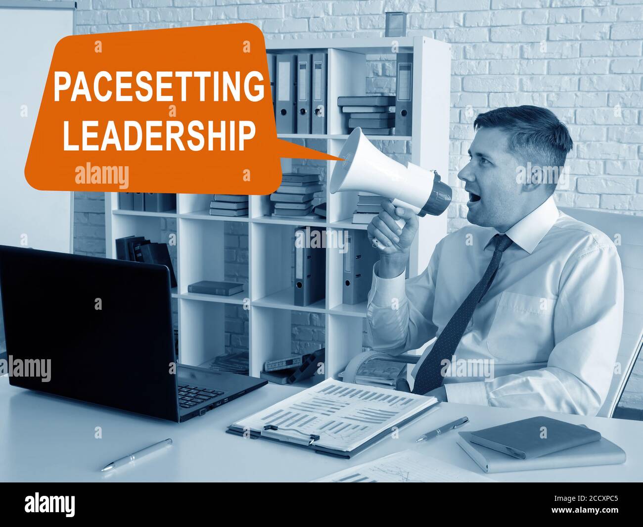 Pacesetting leadership. Manager with loudspeaker in the office Stock ...