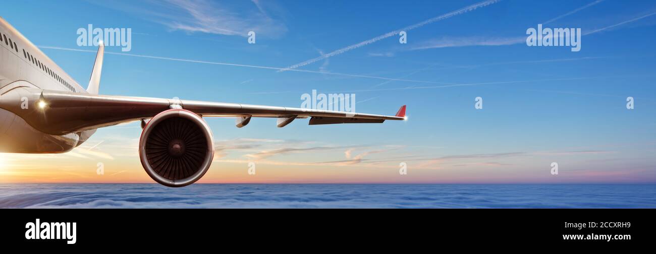 Detail of wing of commercial airplane jetliner flying above clouds in ...