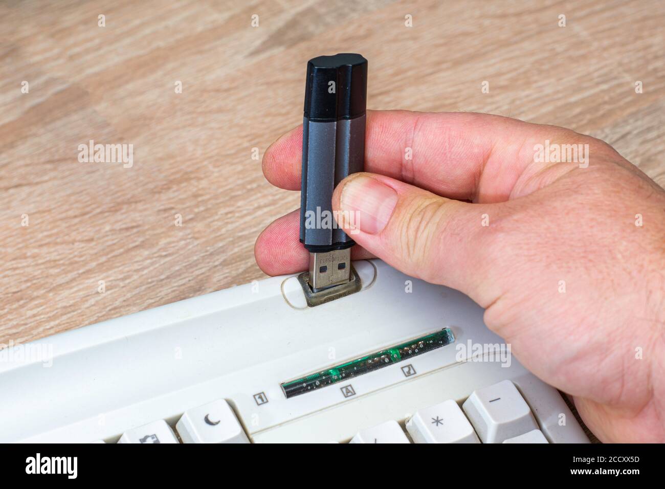 a man's hand inserts a USB flash drive into the connector on the ...