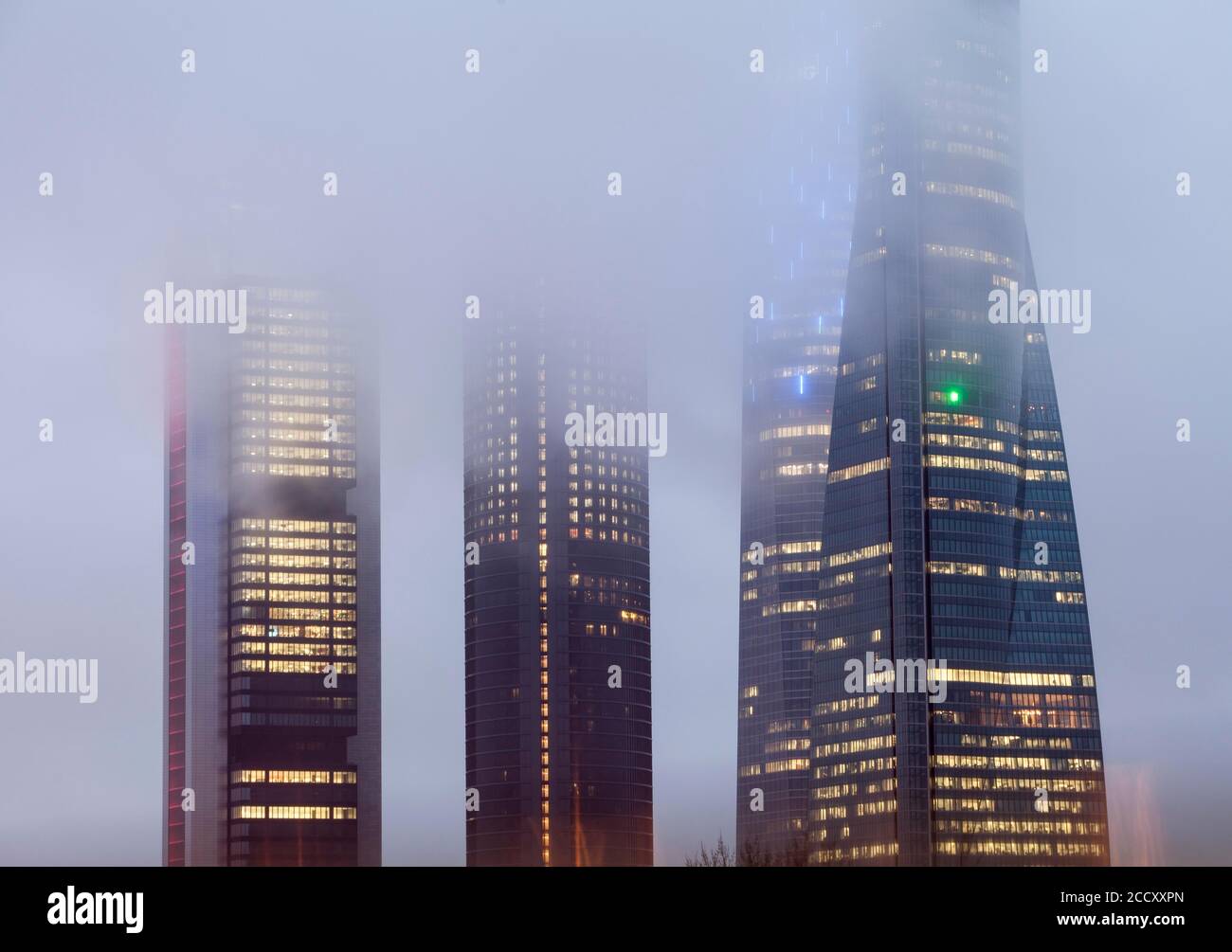 Cuatro Torres Business Area Office building illuminated in evening fog ...