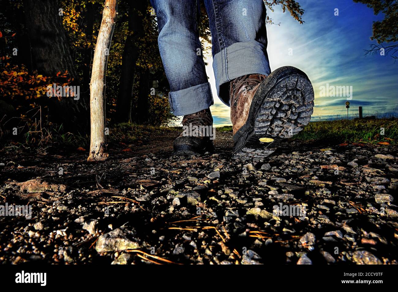 Close-up, Hiker with walking stick walking on gravel path, hiking boots ...