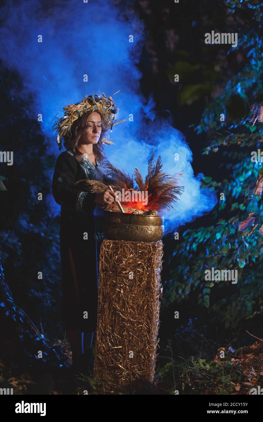 A forest witch brews a potion holding a Voodoo doll Stock Photo - Alamy