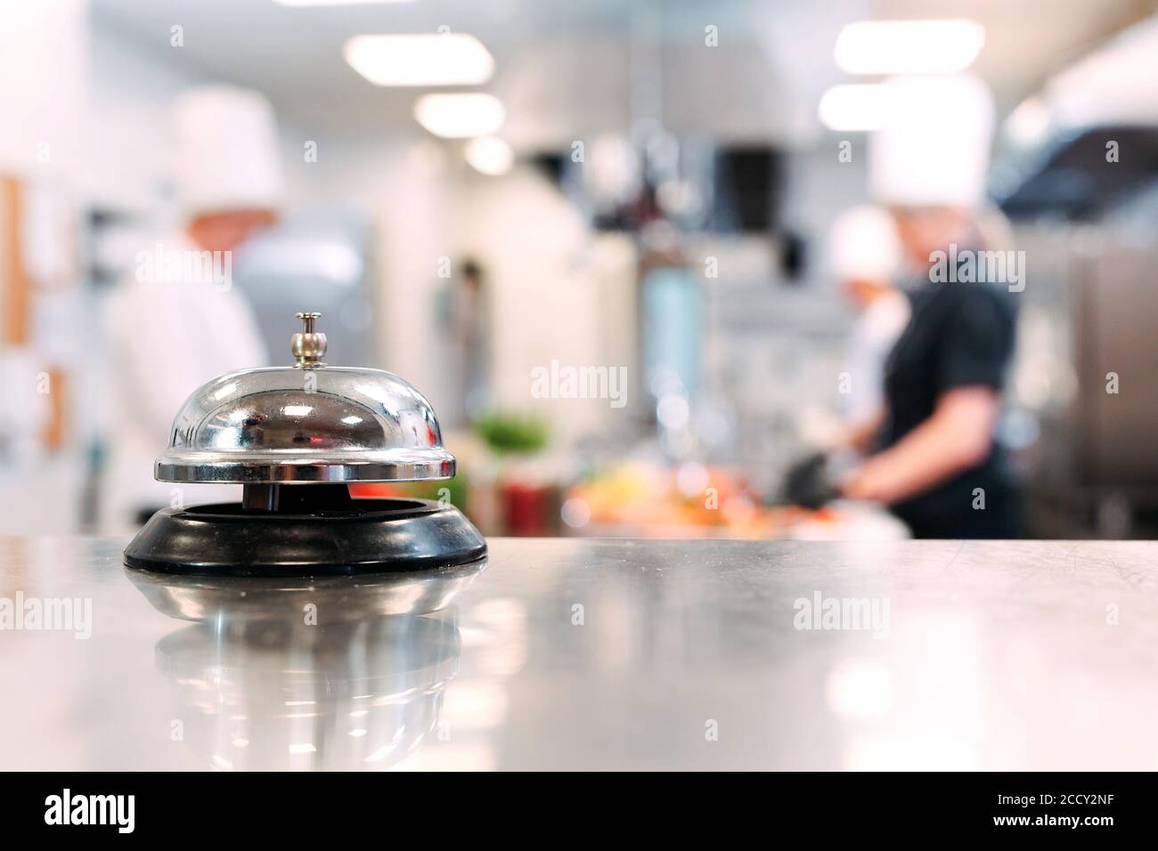Table distribution in the restaurant. Cooks prepare food in the kitchen ...