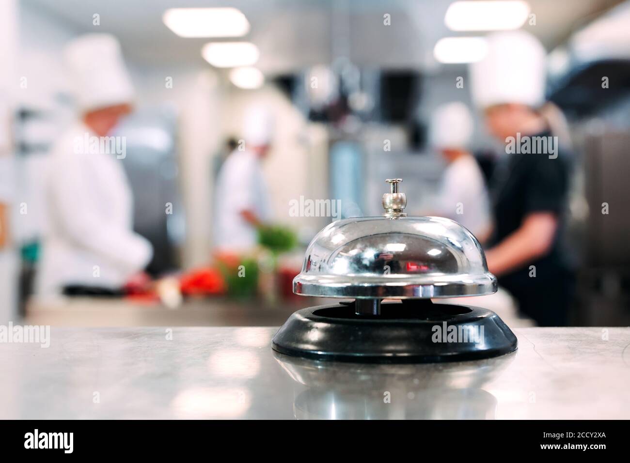 Table distribution in the restaurant. Cooks prepare food in the kitchen ...