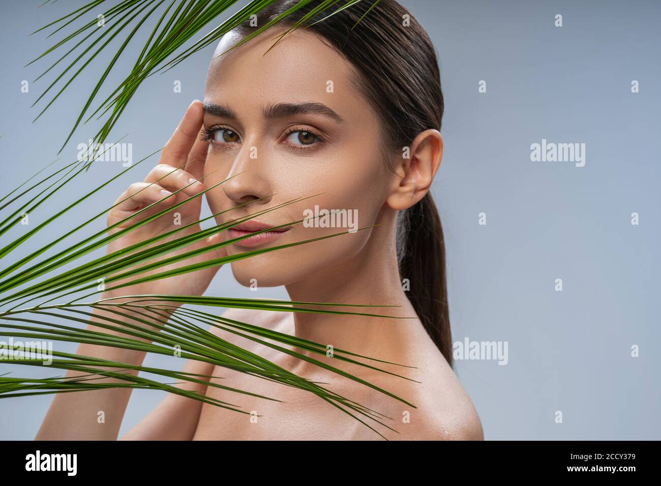 Female with palm fronds posing for the camera Stock Photo - Alamy