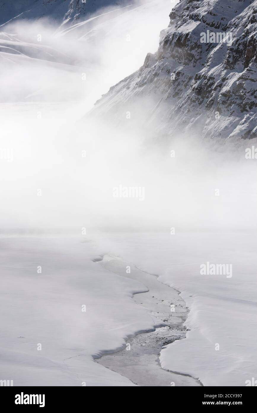 River flowing through snow covered mountains in Spiti, a high altitude ...