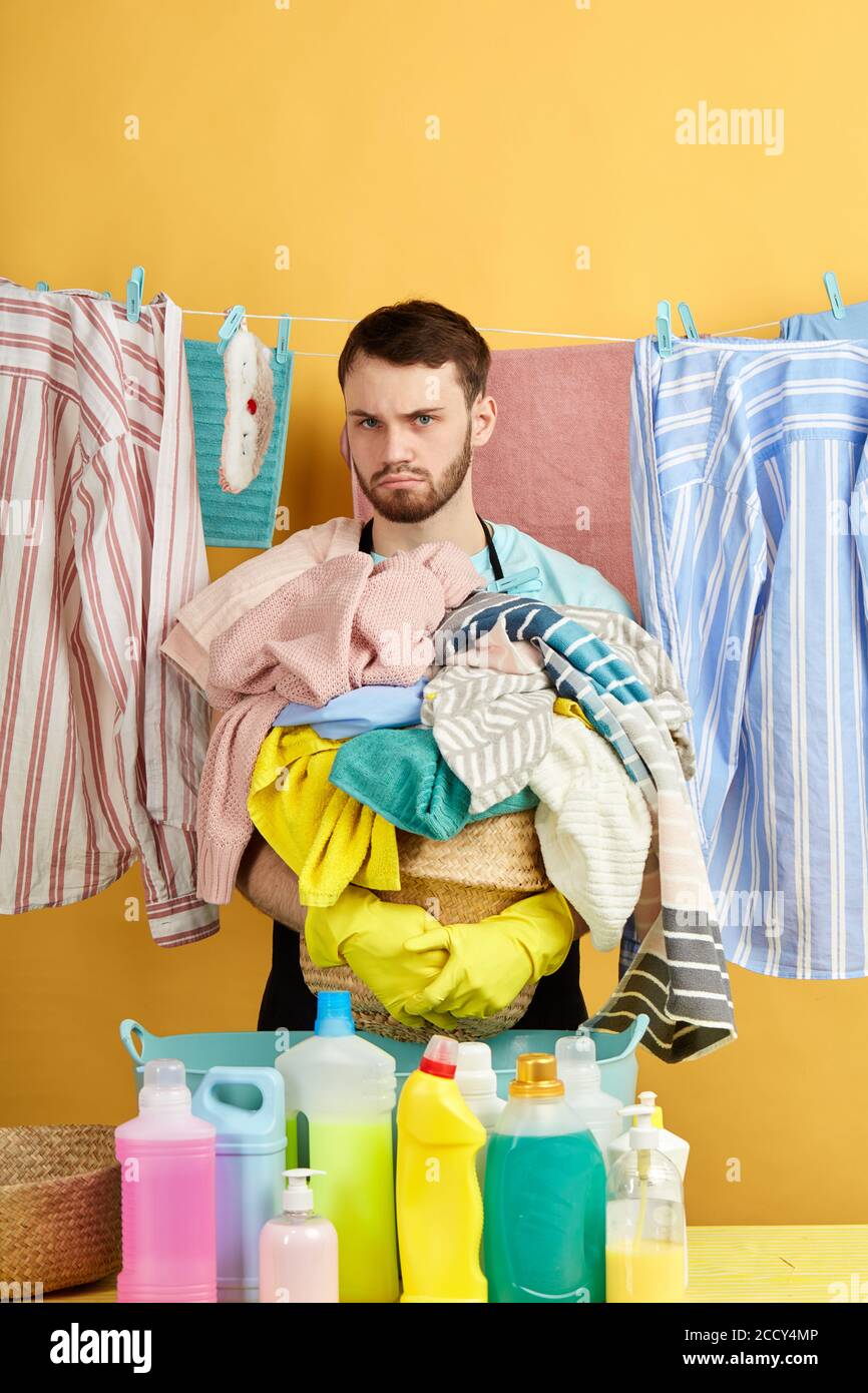 angry man with stack of dirty clothes in hands looking at camera ...