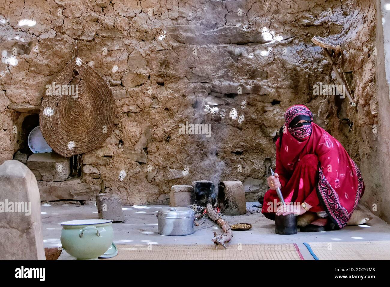 Local woman makes coffee over open fire in traditional house, Oman ...