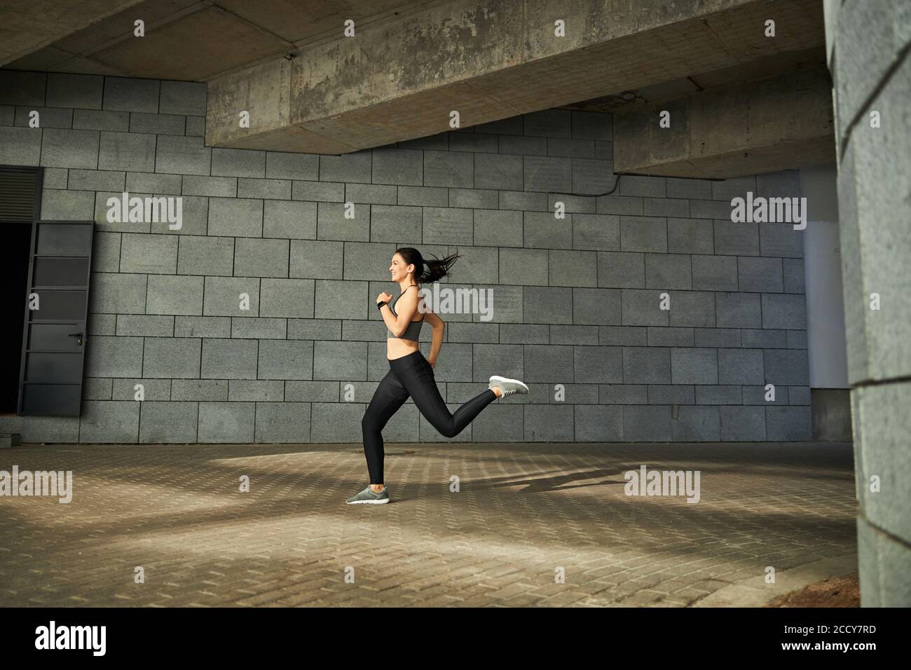 Active female person running quickly on the sidewalk Stock Photo - Alamy