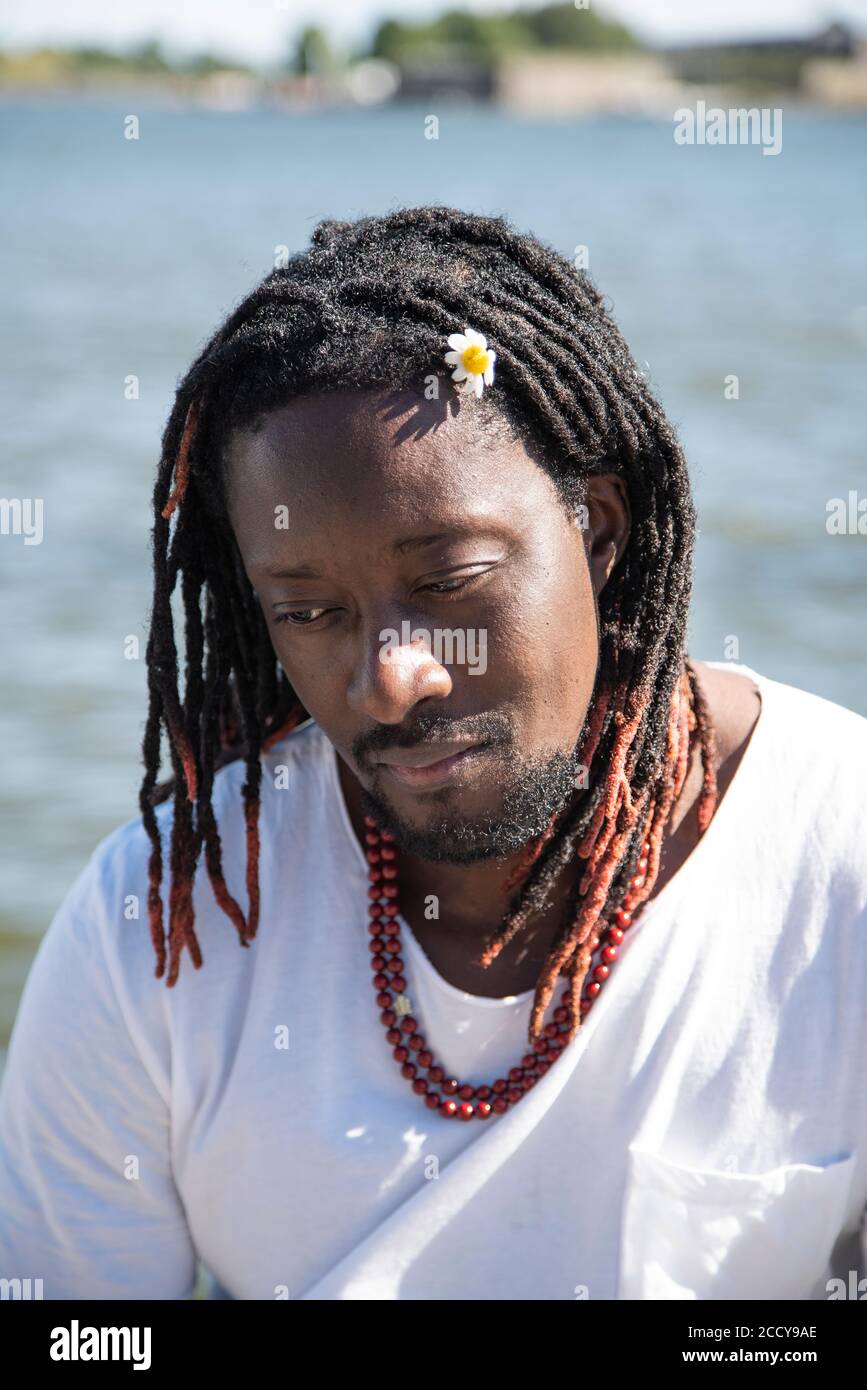 The guy of the African race, dreadlocks hairstyle, chamomile in his ...