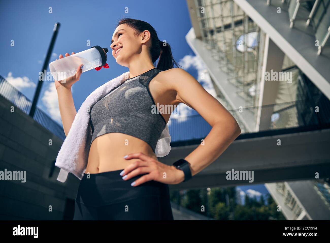 Low angle photo of cute woman drinking water Stock Photo - Alamy