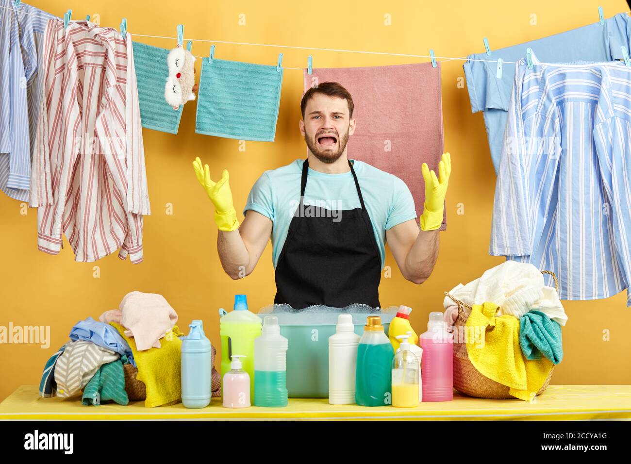 emotional angry man with raised arms standing behind the table, hate ...