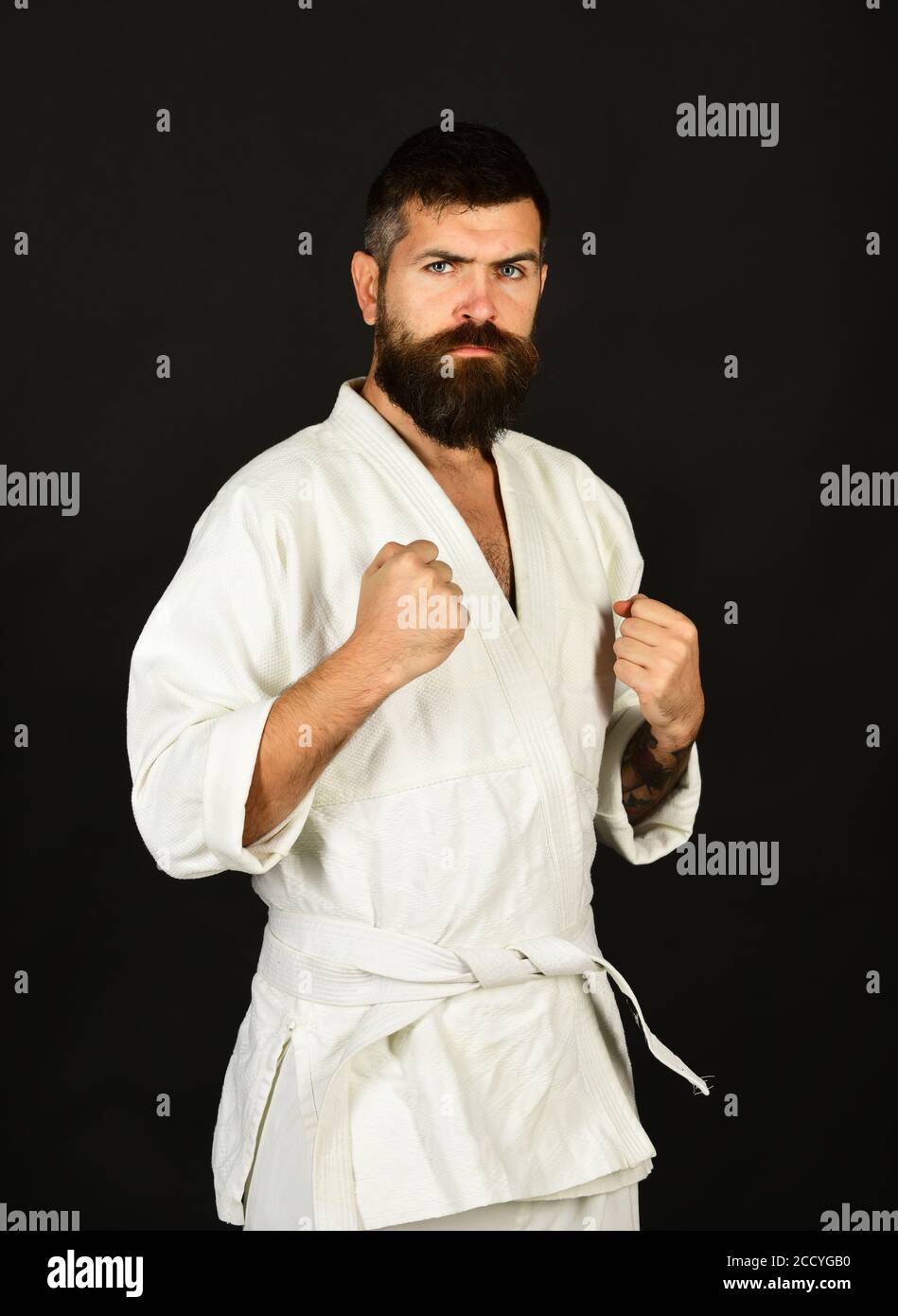 Man with beard in white kimono on black background. Jiu Jitsu master ...