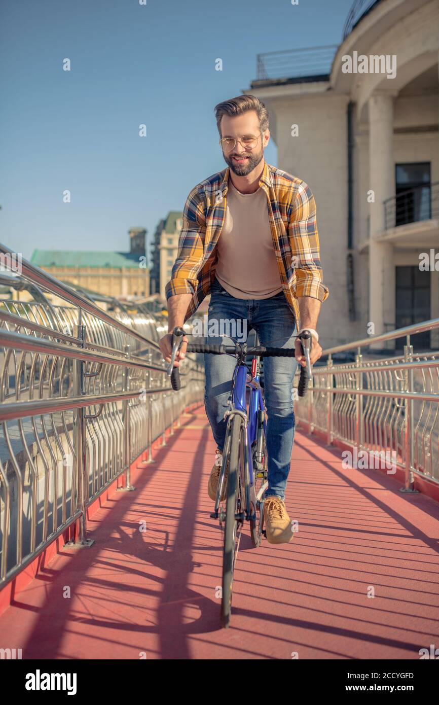 Man on bicycle riding road straight to camera Stock Photo - Alamy