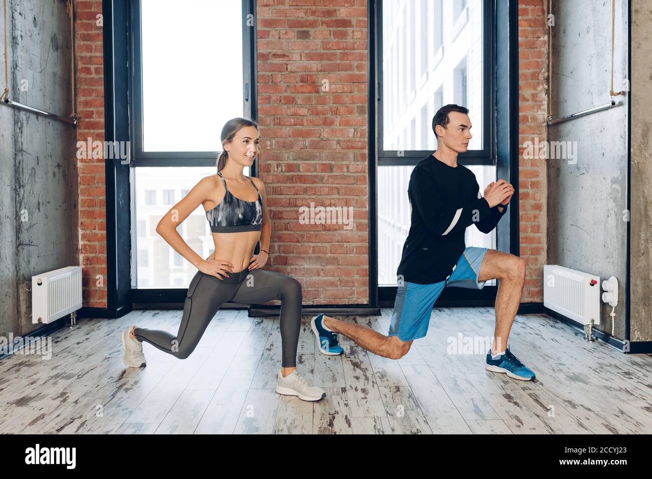 muscular cheerful girl and guy doing sit ups on one leg. side view full ...