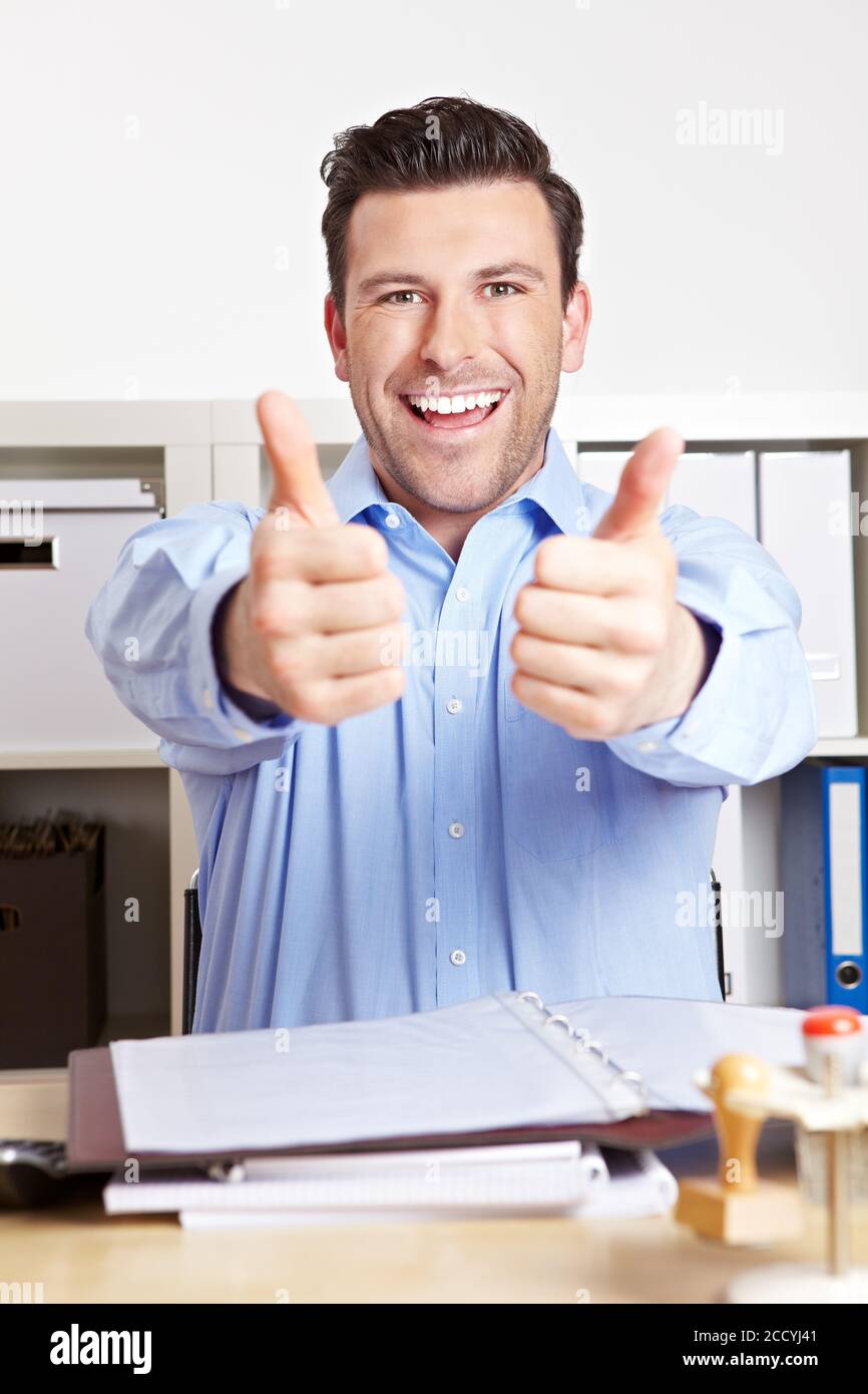 Cheering manager in the office holds both thumbs up Stock Photo - Alamy