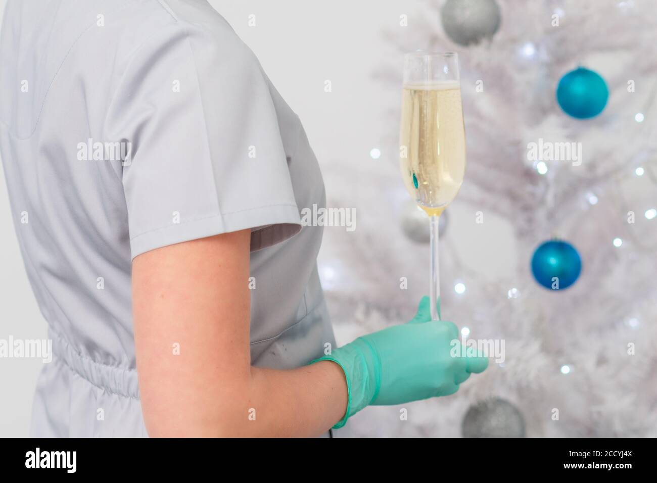 Beautiful young female doctor in protective gloves with glass of ...
