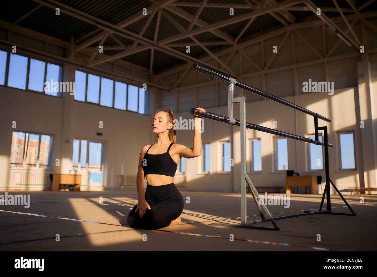 Bright delighted woman sitting on floor in yoga pose with closed eyes ...