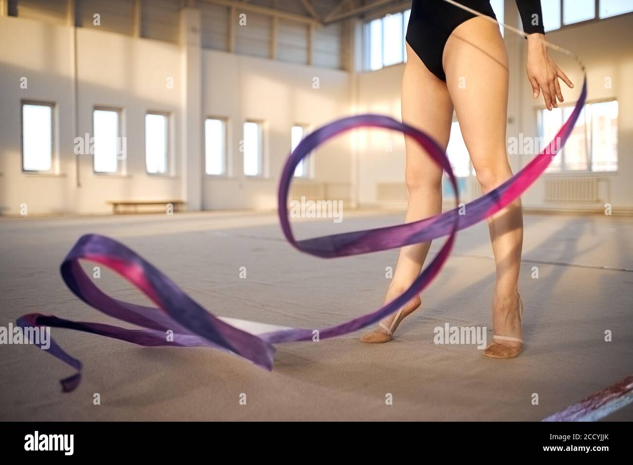 Tall legs of young talented girl dressed in black leotard, standing on ...