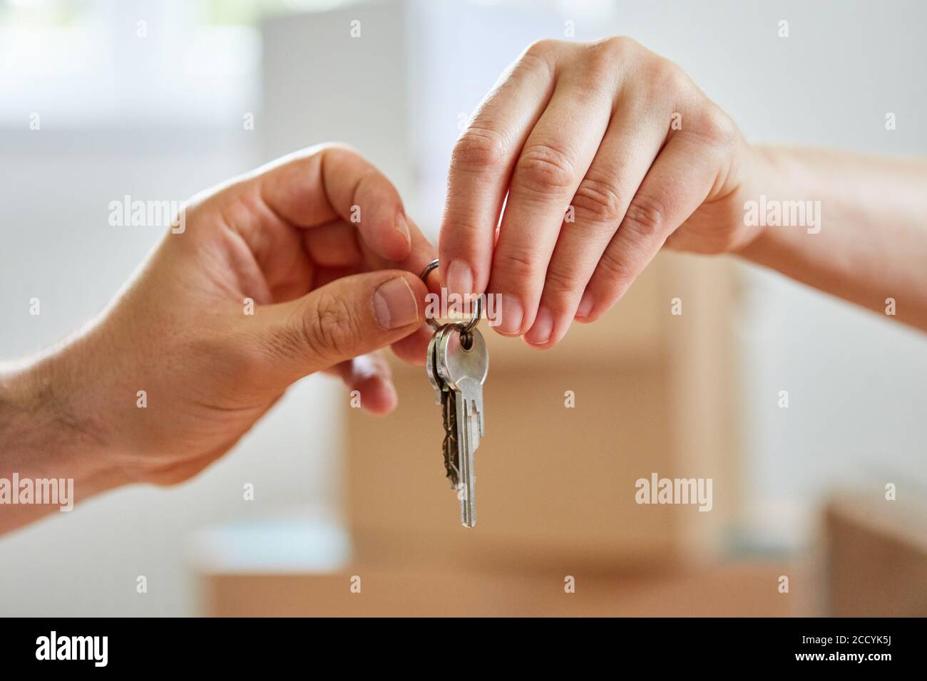 Two hands handing over the keys for the new house or condominium Stock ...