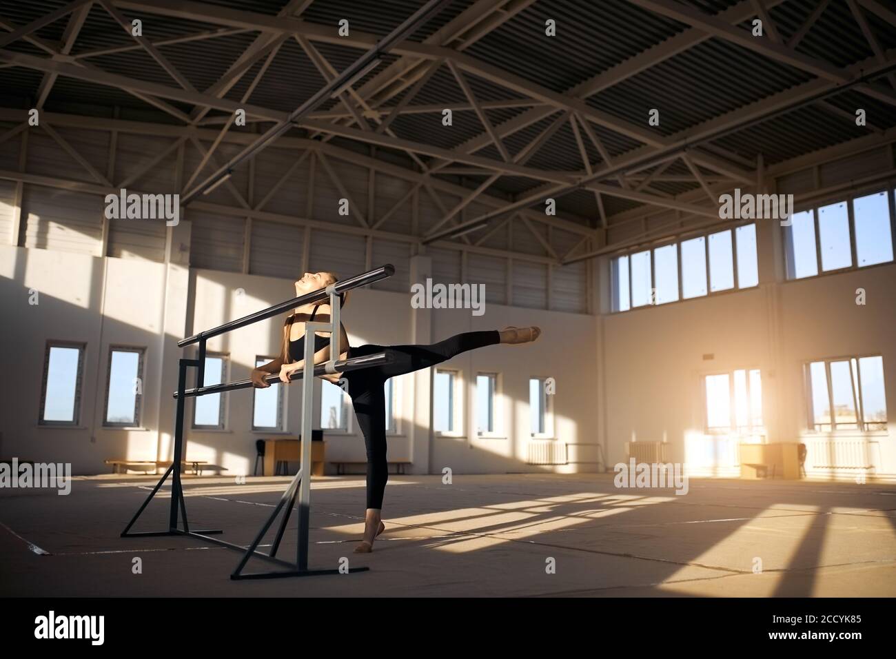 Beautiful pretty girl performing acrobatics element standing by metal ...