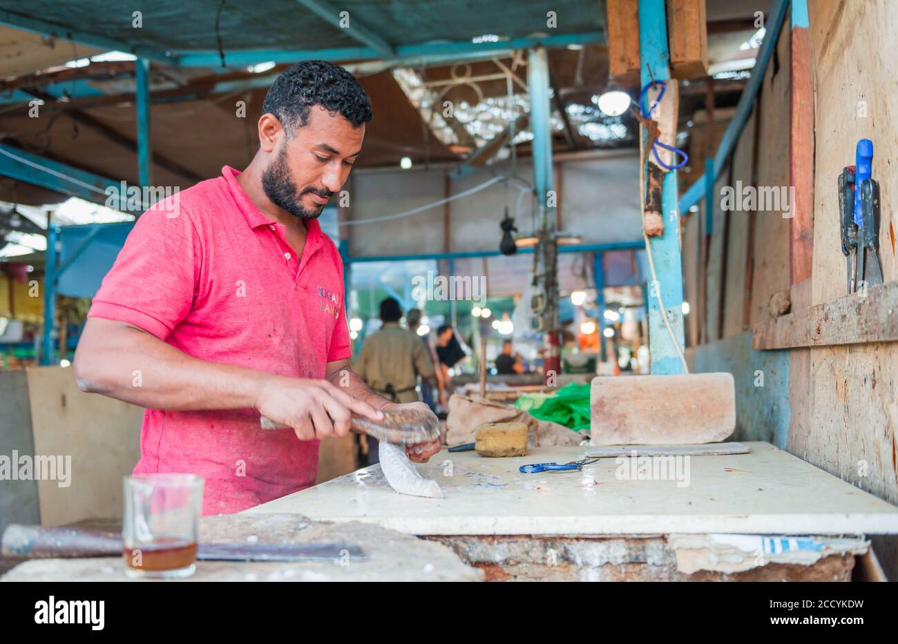 egyptian fish market worker cleaning fresh fish on market table to ...