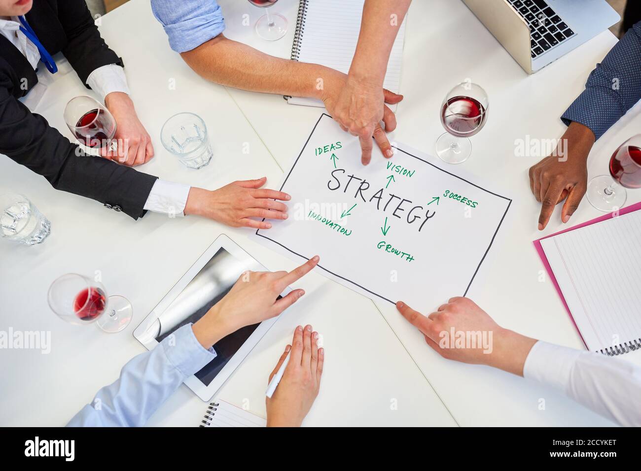 Hands of business people point to a strategy plan in business meeting ...