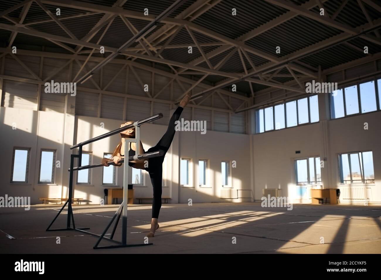 graceful pretty art gymnast making semi splits in the air standing on ...