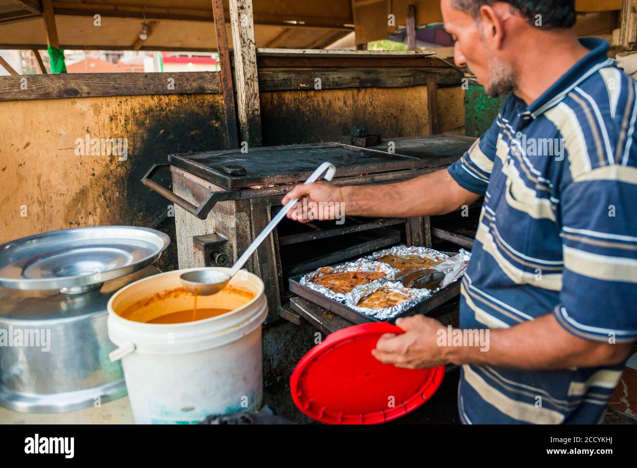Egypt, Hurgada local chef man cooking preparing shrimps on vintage ...