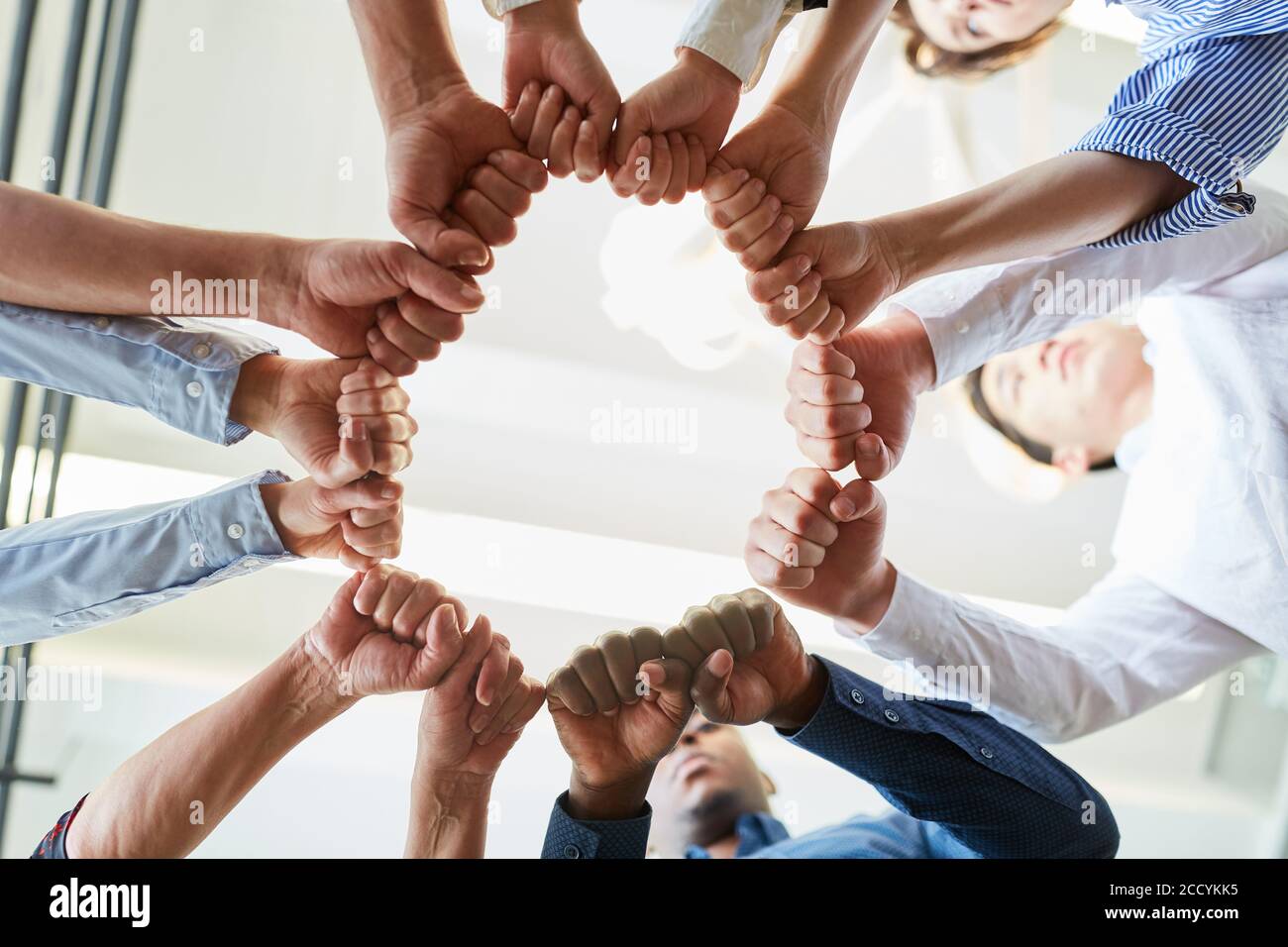 Business people with clenched fists in a circle for team building and ...