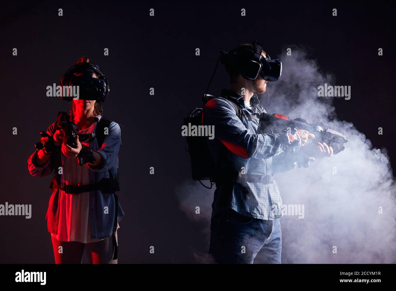 Studio photo of gamers standing in smoke. Ultra violet, virtual reality ...