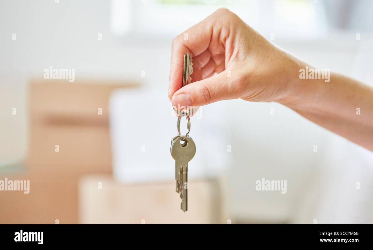 Hand of realtor or owner holding keys to new house after moving in ...