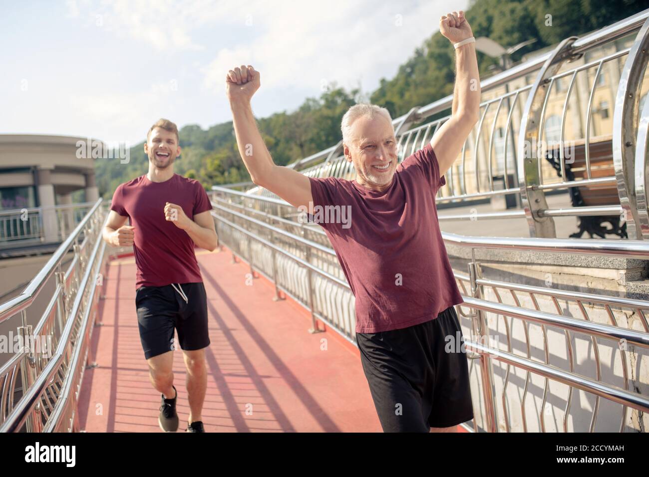 Mature grey-haired male raising both hands, winning running race Stock ...